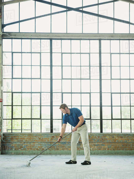 Caucasian businessman sweeping warehouse floor - Royalty-free Stock ...