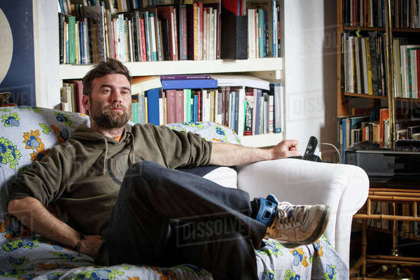 Caucasian man sitting on sofa in living room - Royalty-free Stock Photo ...