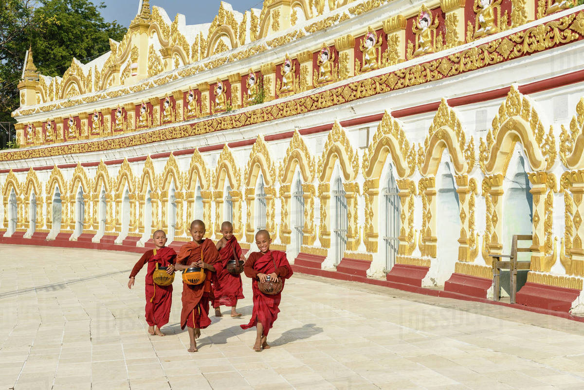 Asian monks-in-training running outside ornate temple - Royalty-free ...