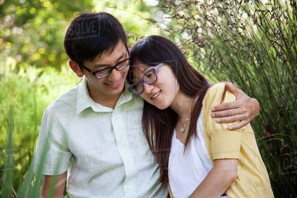 Asian couple hugging outdoors - Stock Photo - Dissolve