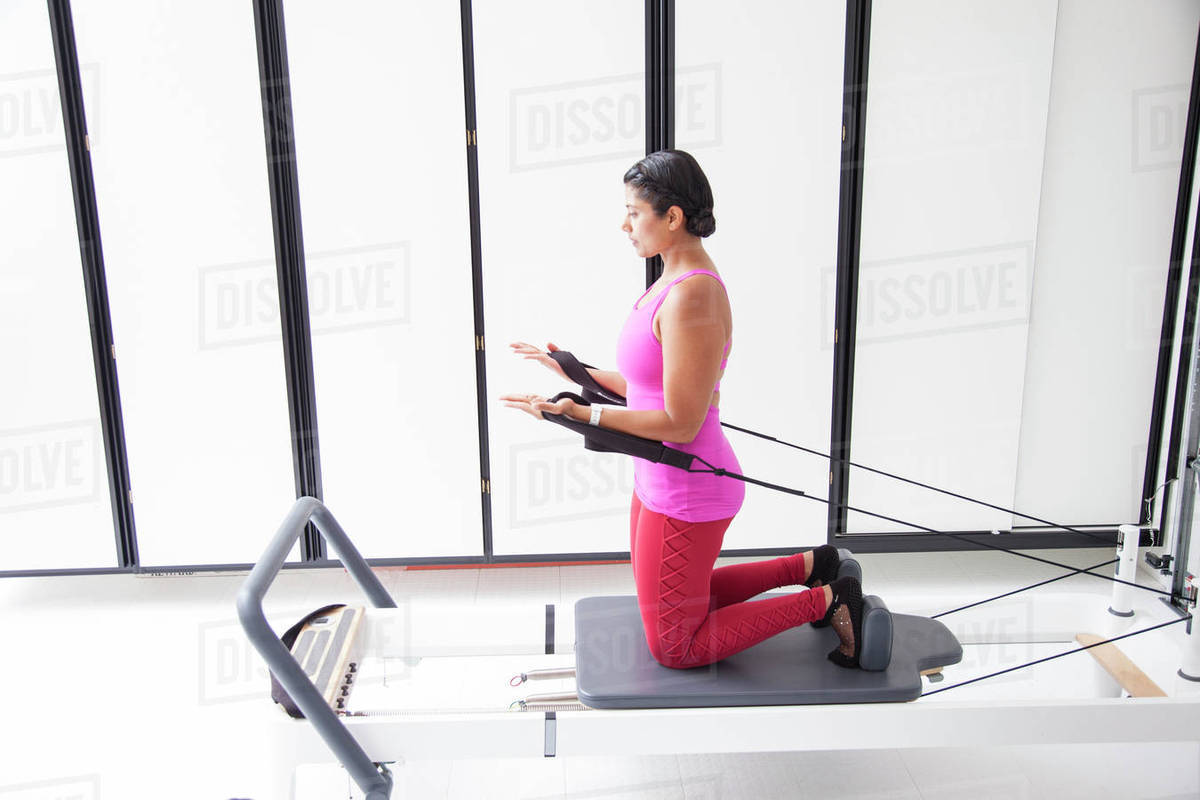Asian woman using exercise machine in gymnasium - Stock Photo - Dissolve