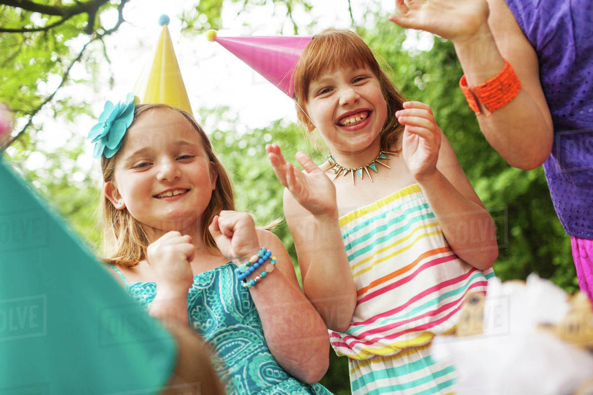 Girls clapping at birthday party outdoors - Stock Photo - Dissolve