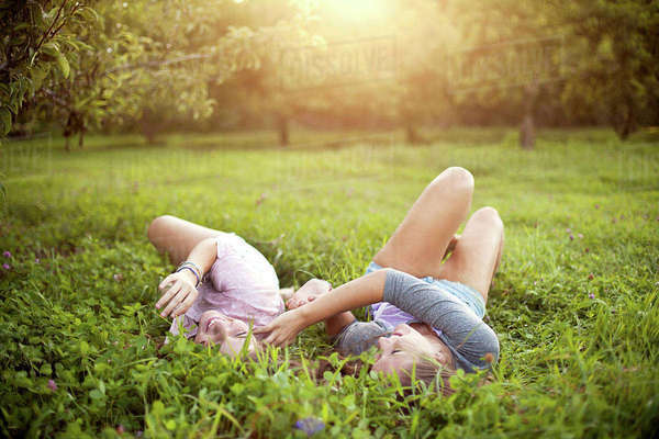 Caucasian women laying in rural field - Stock Photo - Dissolve