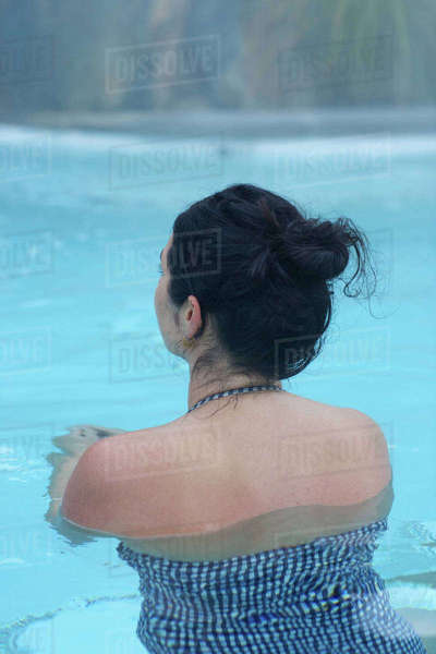 Rear view of woman swimming in pool - Stock Photo - Dissolve