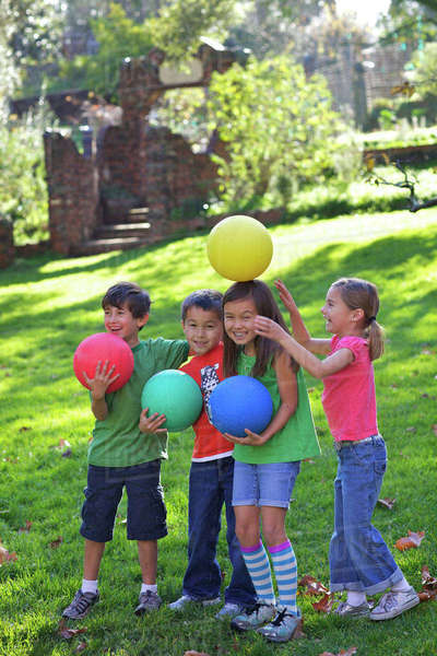Children playing with balls in grass - Stock Photo - Dissolve