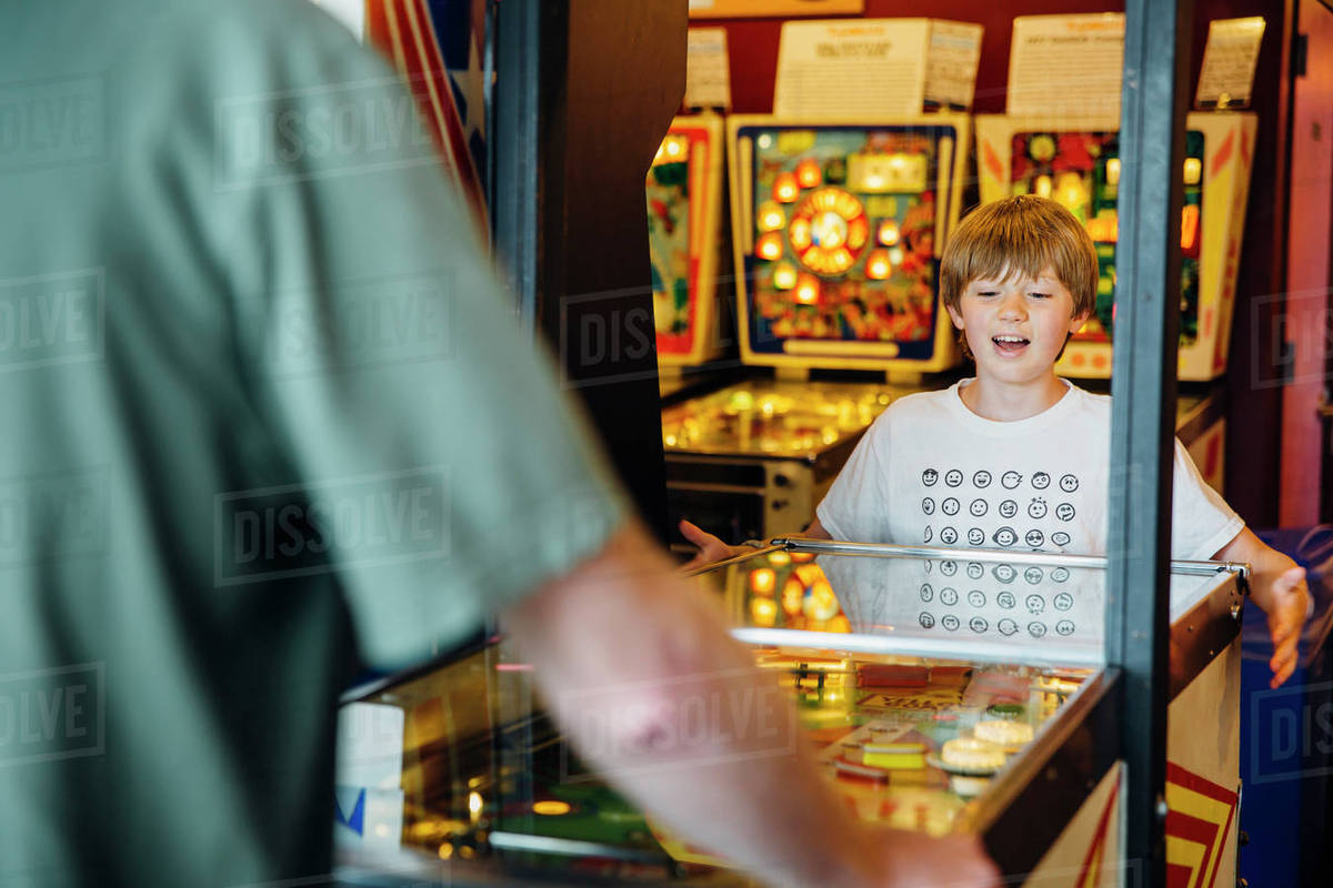 Caucasian father and son playing game in arcade - Royalty-free Stock ...