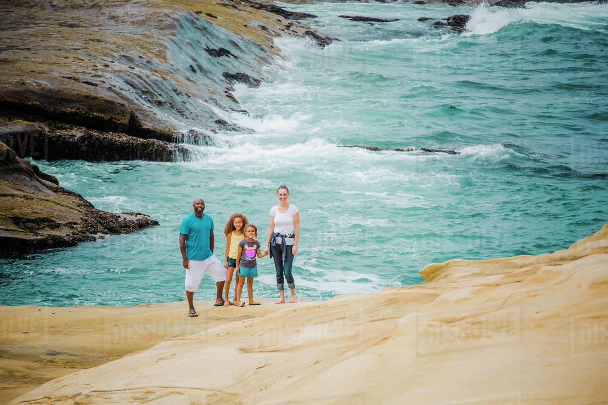 Family smiling on beach - Stock Photo - Dissolve