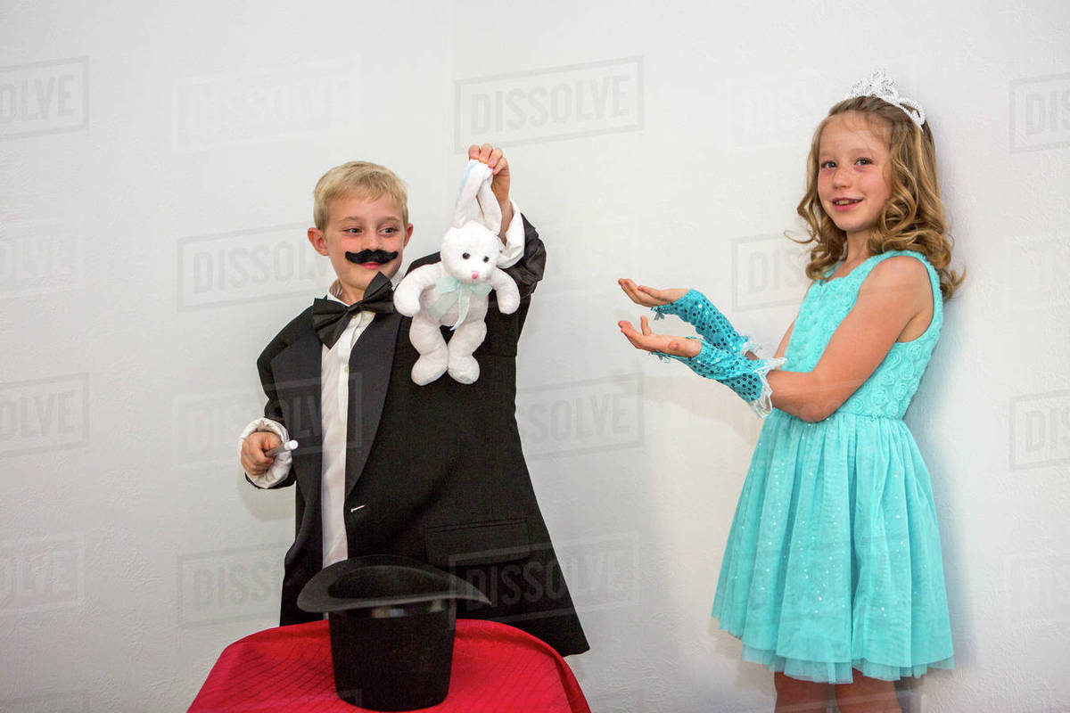 Caucasian magician pulling rabbit from hat - Stock Photo - Dissolve
