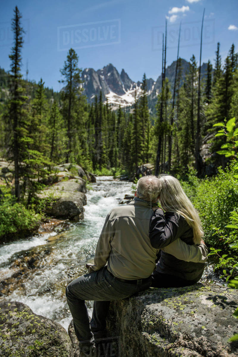 Caucasian couple hugging on rock at mountain river - Royalty-free Stock ...