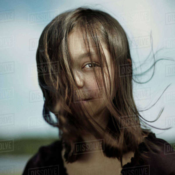 Hair of serious Caucasian girl blowing in wind - Stock Photo - Dissolve