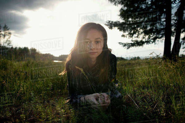 Caucasian girl laying in grass field - Royalty-free Stock Photo | Dissolve