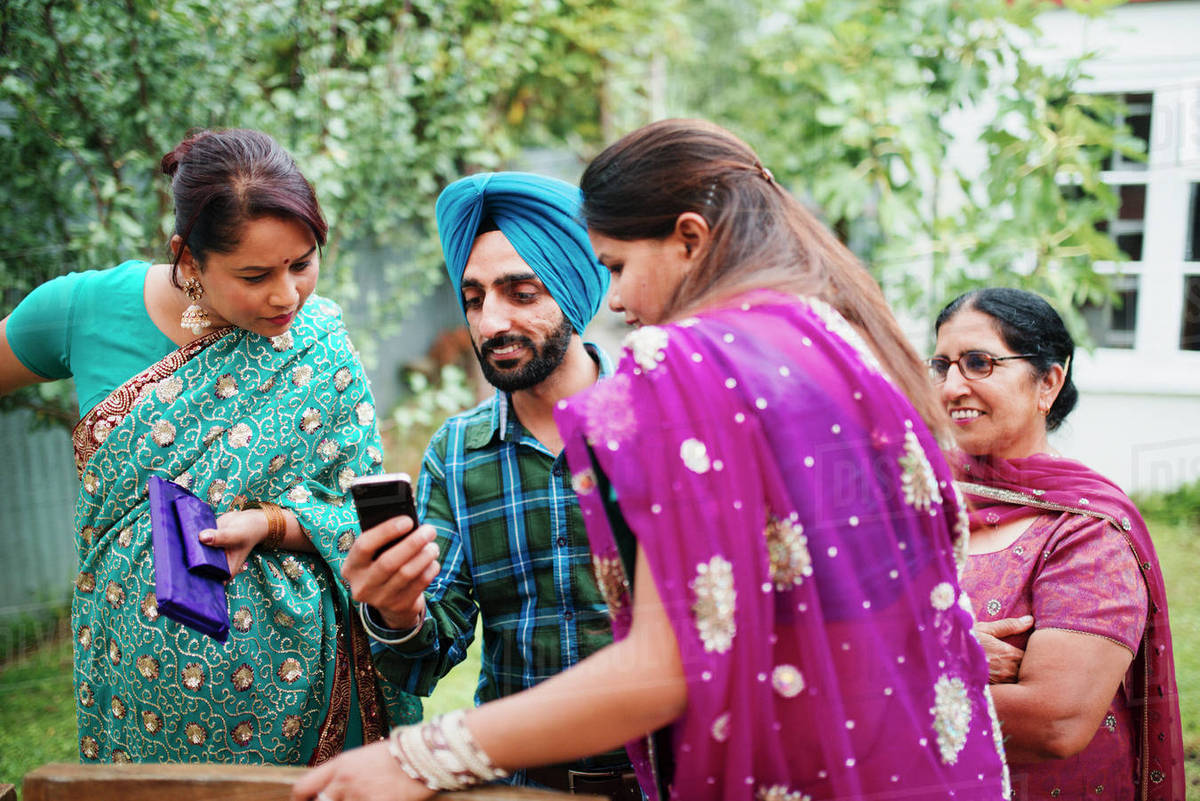 Family using cell phone in backyard - Royalty-free Stock Photo | Dissolve