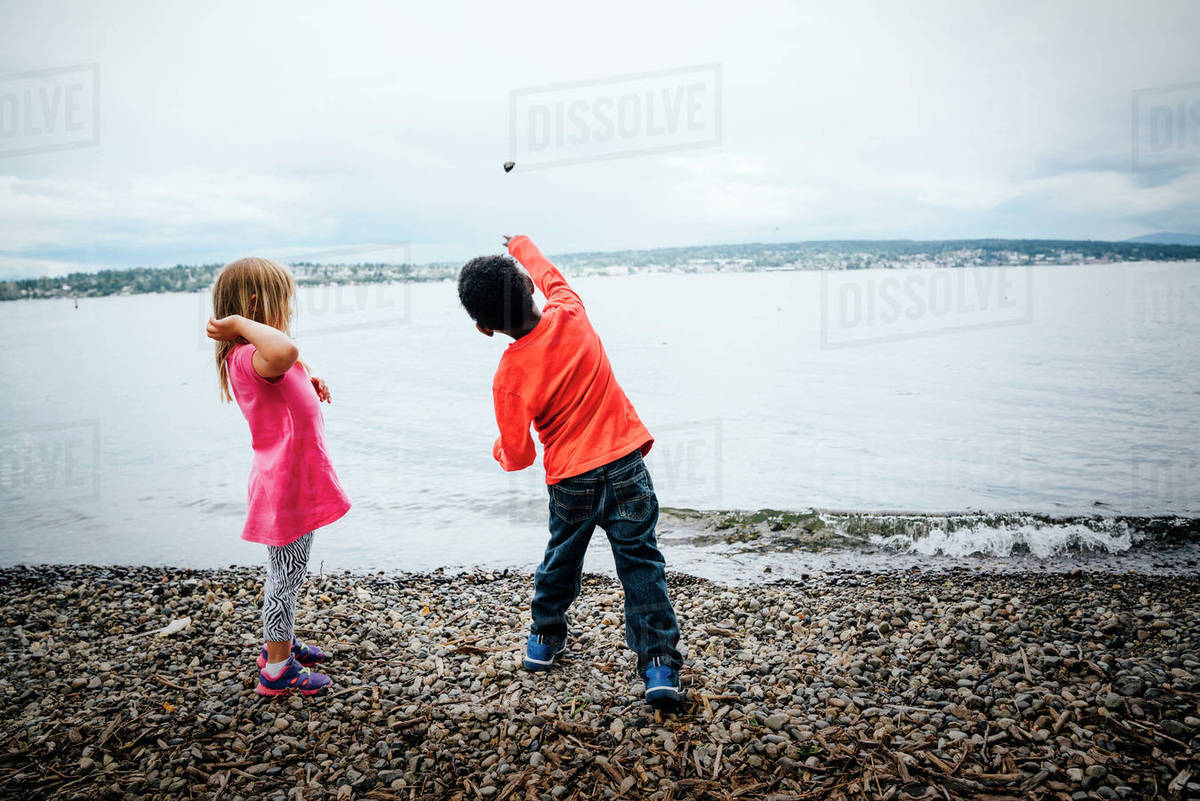 Boy and girl throwing rocks into river - Royalty-free Stock Photo ...