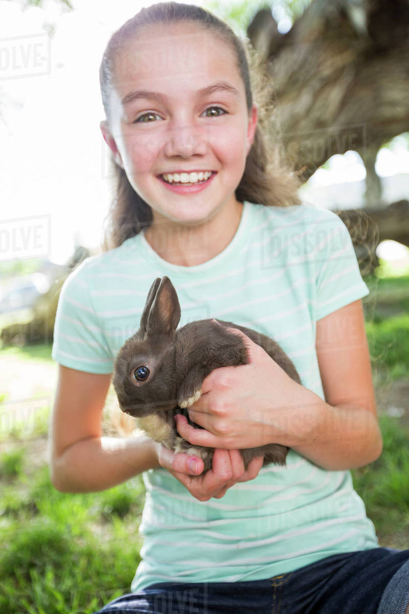 Caucasian girl holding rabbit - Royalty-free Stock Photo | Dissolve