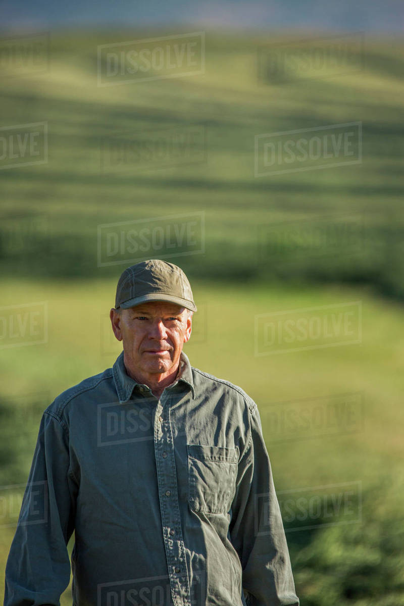 Caucasian farmer standing in field - Royalty-free Stock Photo | Dissolve