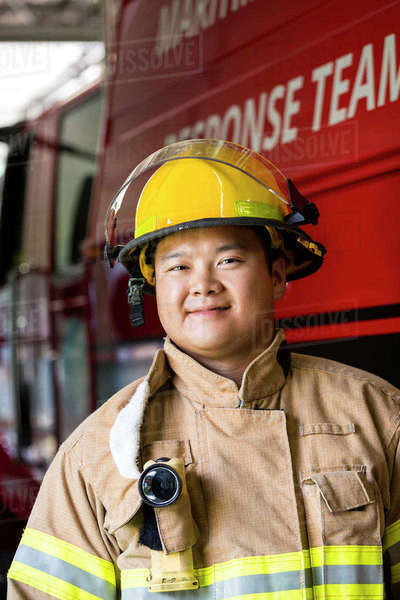 Smiling Chinese fireman standing near fire truck - Royalty-free Stock ...