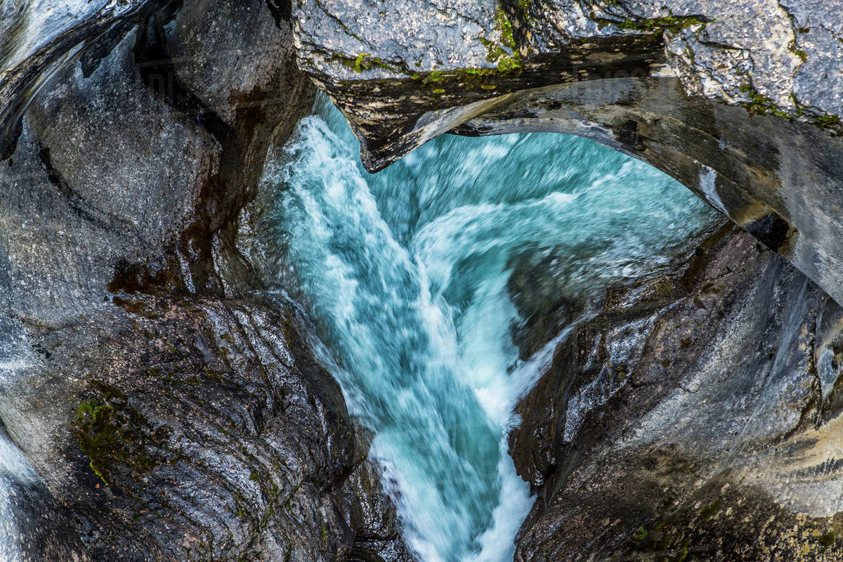 Rapids flowing under rocks - Stock Photo - Dissolve