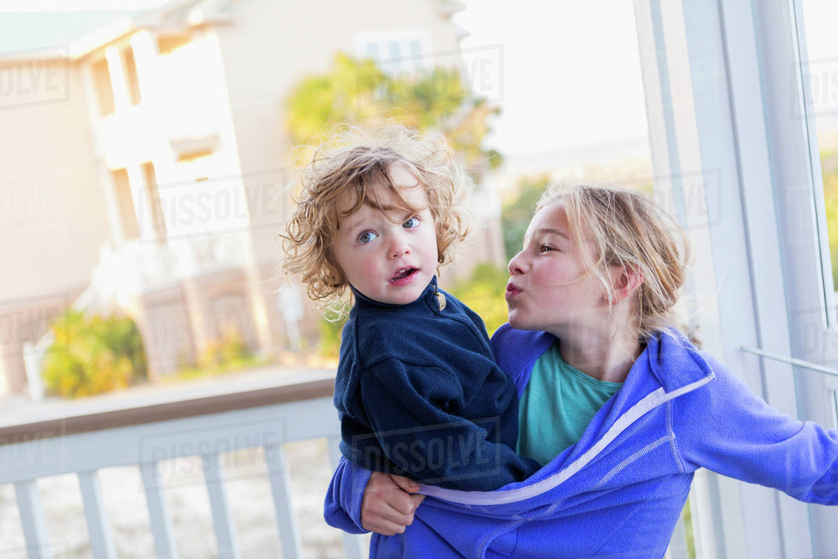 Caucasian girl carrying baby brother on porch - Royalty-free Stock ...