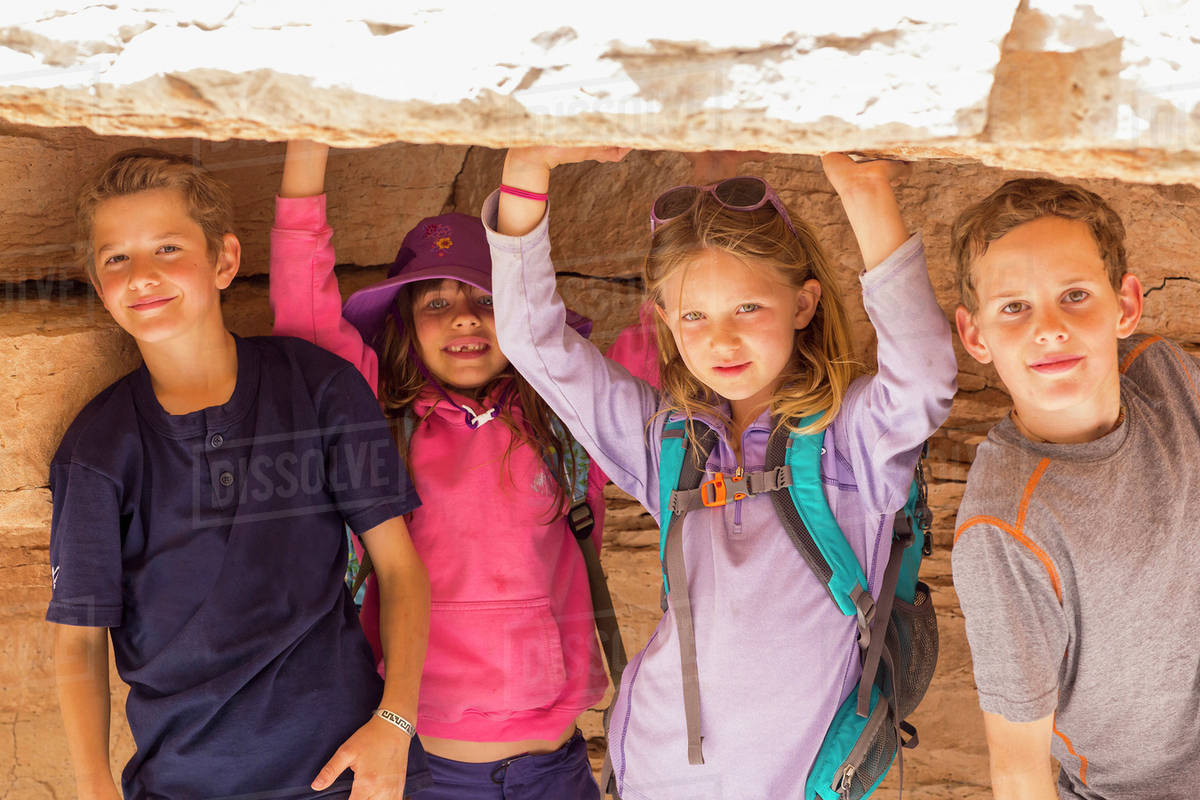 Children crouching under rock formation - Royalty-free Stock Photo ...