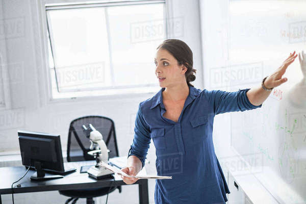 Professor pointing to whiteboard - Royalty-free Stock Photo | Dissolve