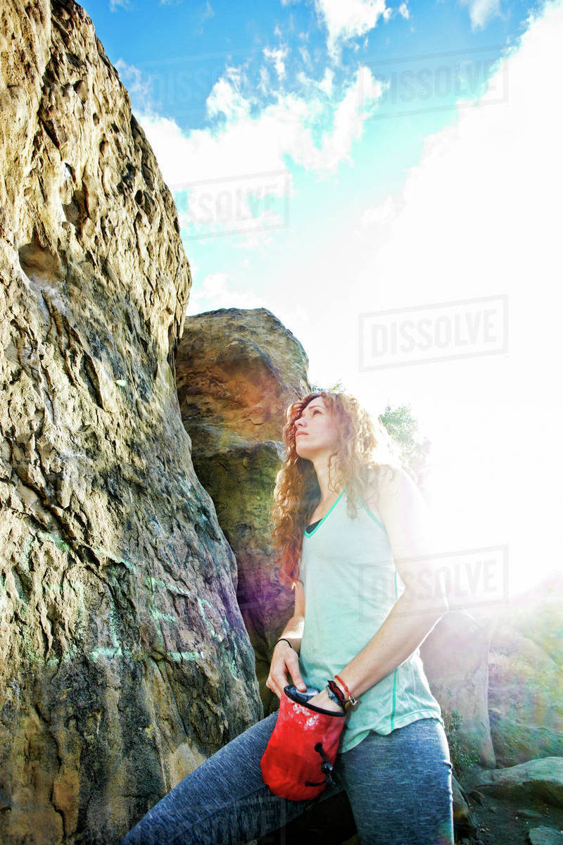 Woman chalking hands for rock climbing - Stock Photo - Dissolve