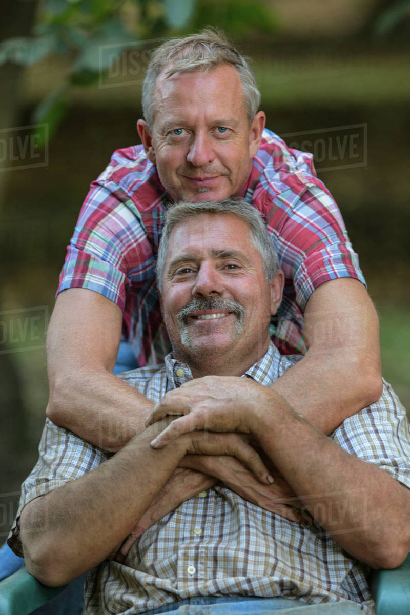 Portrait of smiling men hugging - Royalty-free Stock Photo | Dissolve