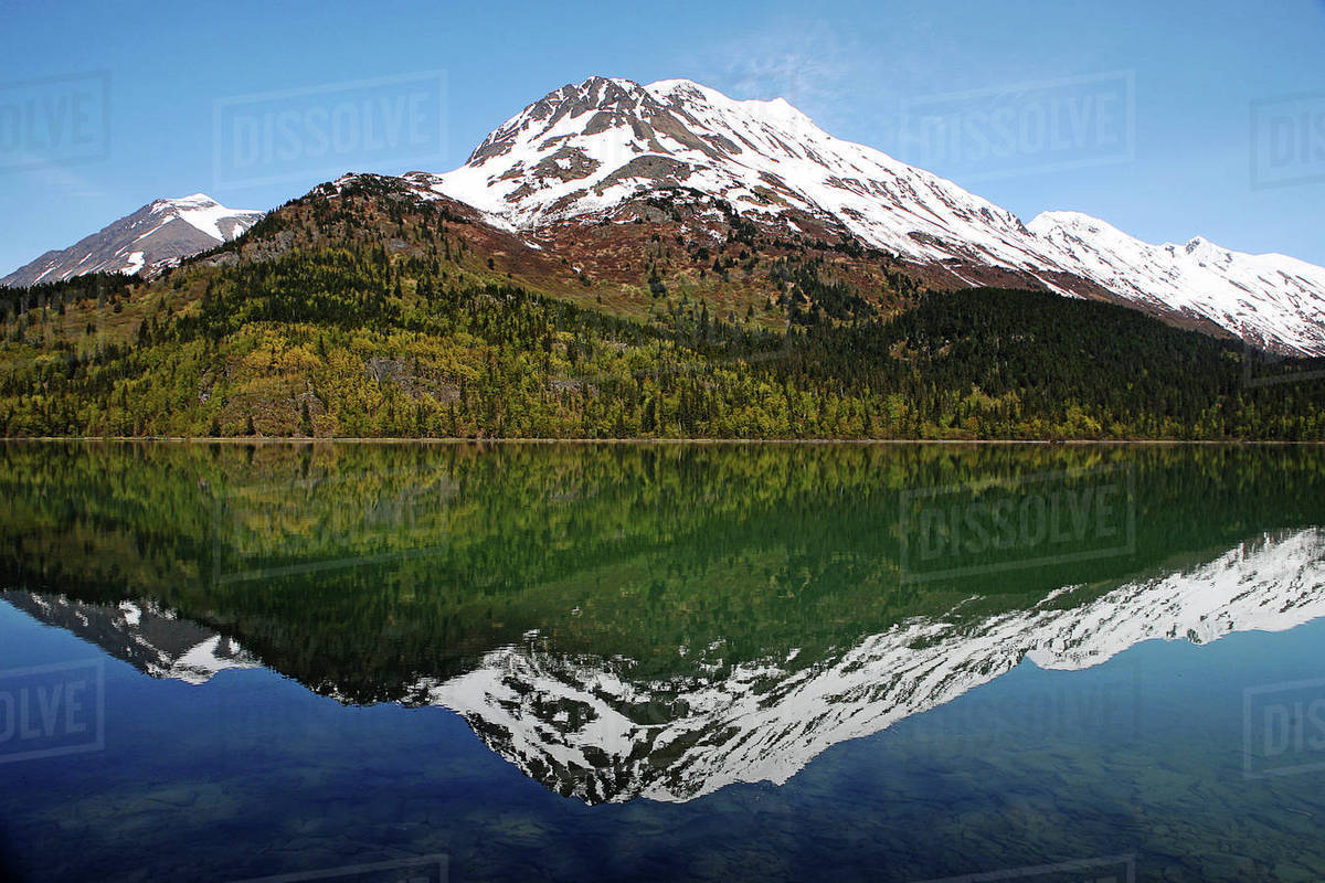 Reflection of mountain in still lake - Stock Photo - Dissolve
