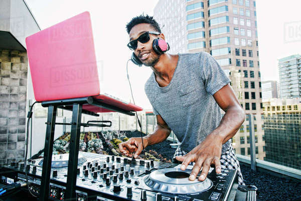 Smiling Black DJ on urban rooftop - Royalty-free Stock Photo | Dissolve