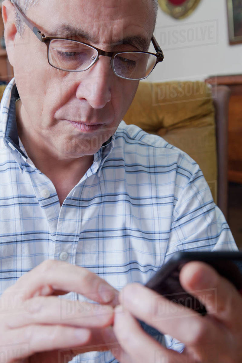 Hispanic man texting on cell phone - Royalty-free Stock Photo | Dissolve