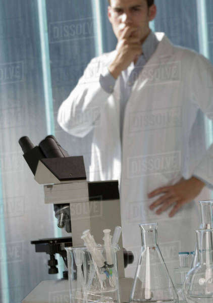 Pensive Caucasian scientist standing in laboratory - Royalty-free Stock ...