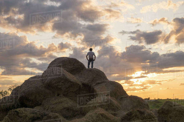 Caucasian man standing on rock pile at sunset - Royalty-free Stock ...
