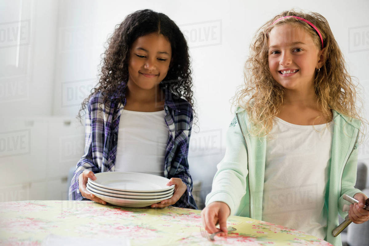 Girls setting the table for meal - Royalty-free Stock Photo | Dissolve