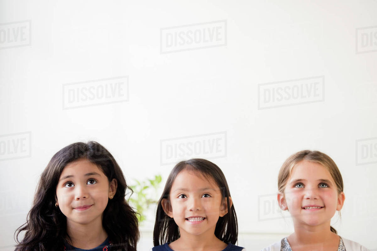 Portrait of smiling girls looking up - Stock Photo - Dissolve