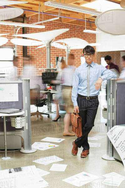 Businessman standing in busy office - Royalty-free Stock Photo | Dissolve