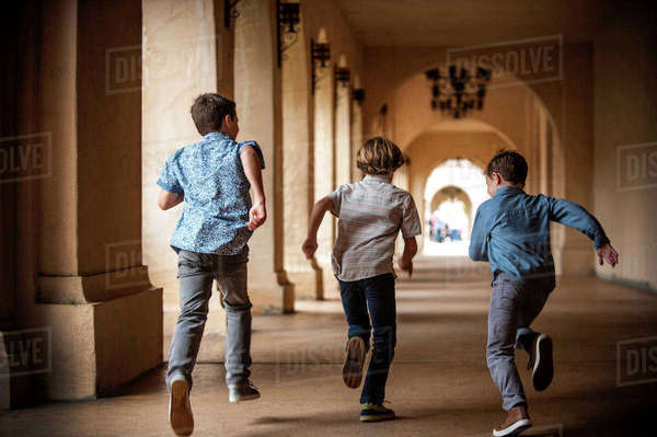 Brothers running near pillars - Stock Photo - Dissolve