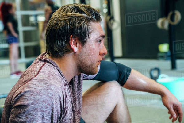 Sweating man resting in gymnasium - Royalty-free Stock Photo | Dissolve