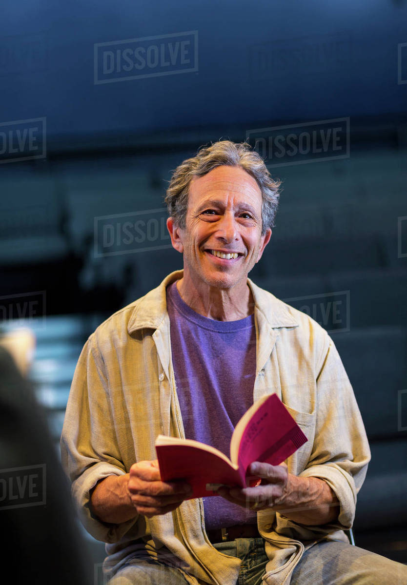 Portrait of smiling actor holding script in theater - Royalty-free ...