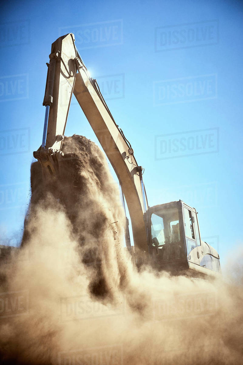 Dust from digger digging dirt - Royalty-free Stock Photo | Dissolve