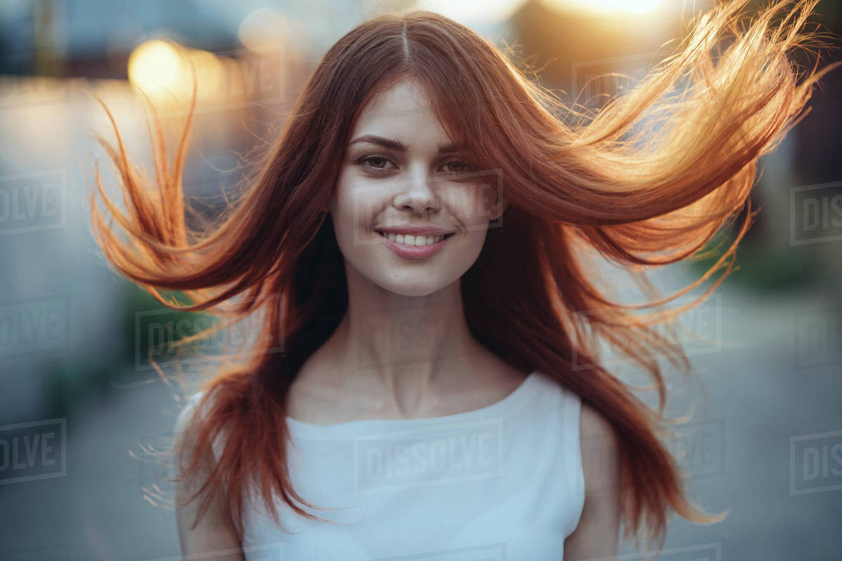 Wind blowing hair of smiling woman - Stock Photo - Dissolve