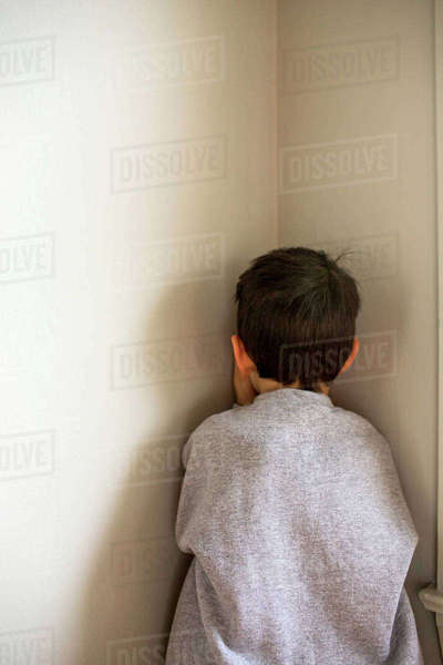 Mixed Race boy standing in corner - Royalty-free Stock Photo | Dissolve
