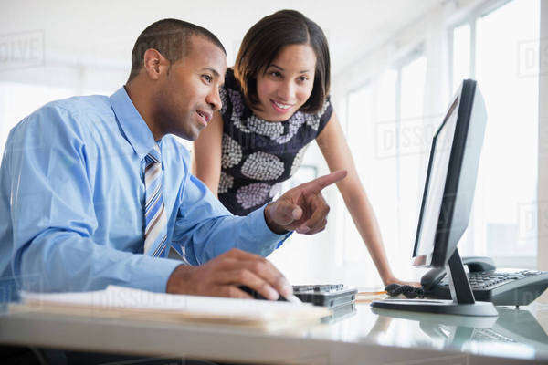 Business people talking at computer - Stock Photo - Dissolve