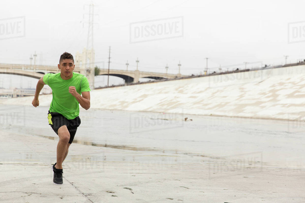 Mixed Race man running in canal - Royalty-free Stock Photo | Dissolve