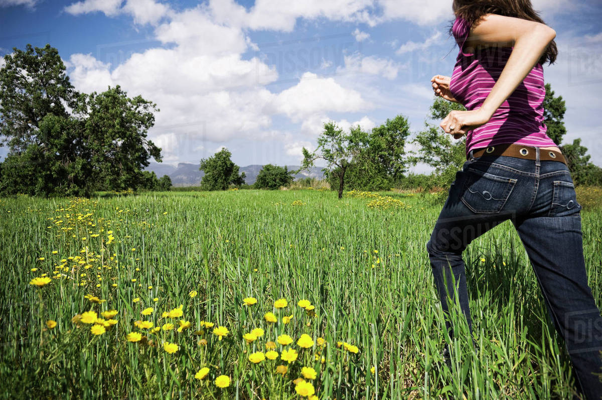 Mixed Race woman running in field - Stock Photo - Dissolve