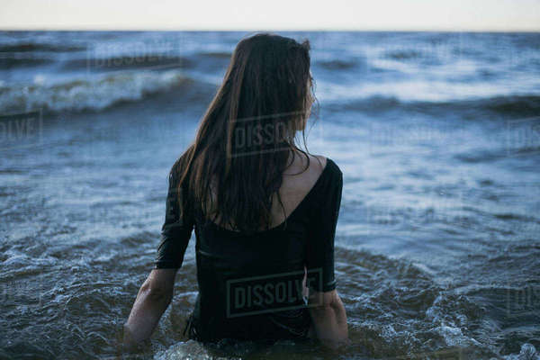 Caucasian woman wearing dress wading in ocean - Royalty-free Stock ...
