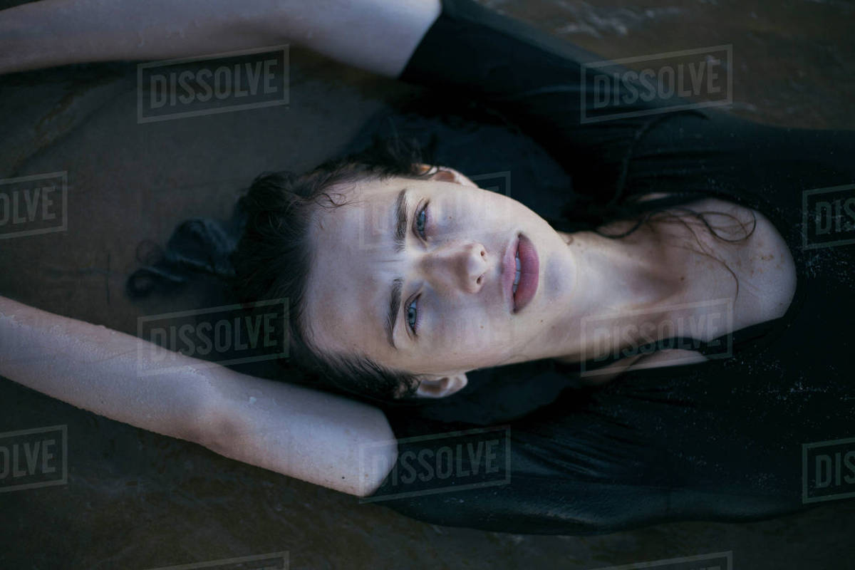 Caucasian woman laying on beach in waves - Royalty-free Stock Photo ...