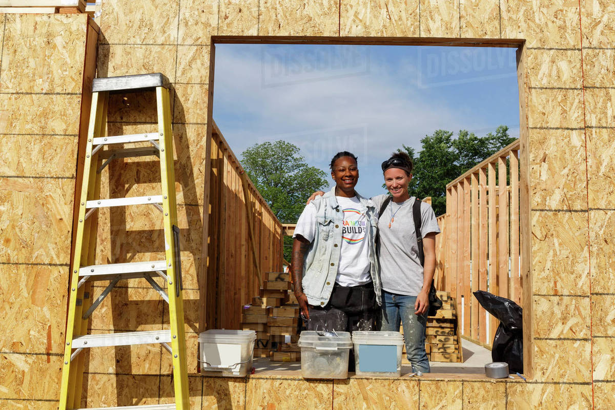 Portrait of volunteers behind window frame at construction site - Stock ...