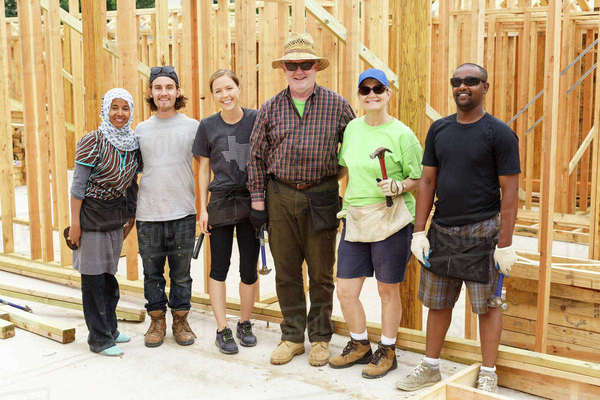 Volunteers posing at construction site - Stock Photo - Dissolve