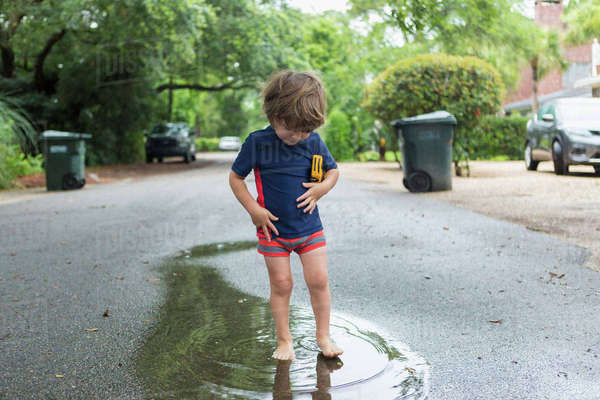 Caucasian boy standing in puddle on street - Royalty-free Stock Photo ...