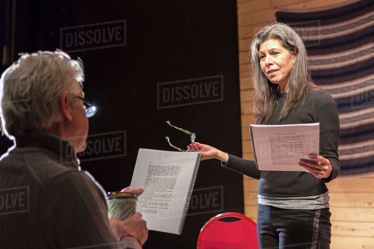 Hispanic man and woman reading scripts on theater stage - Stock Photo ...