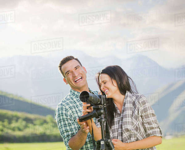 Couple with camera laughing - Stock Photo - Dissolve
